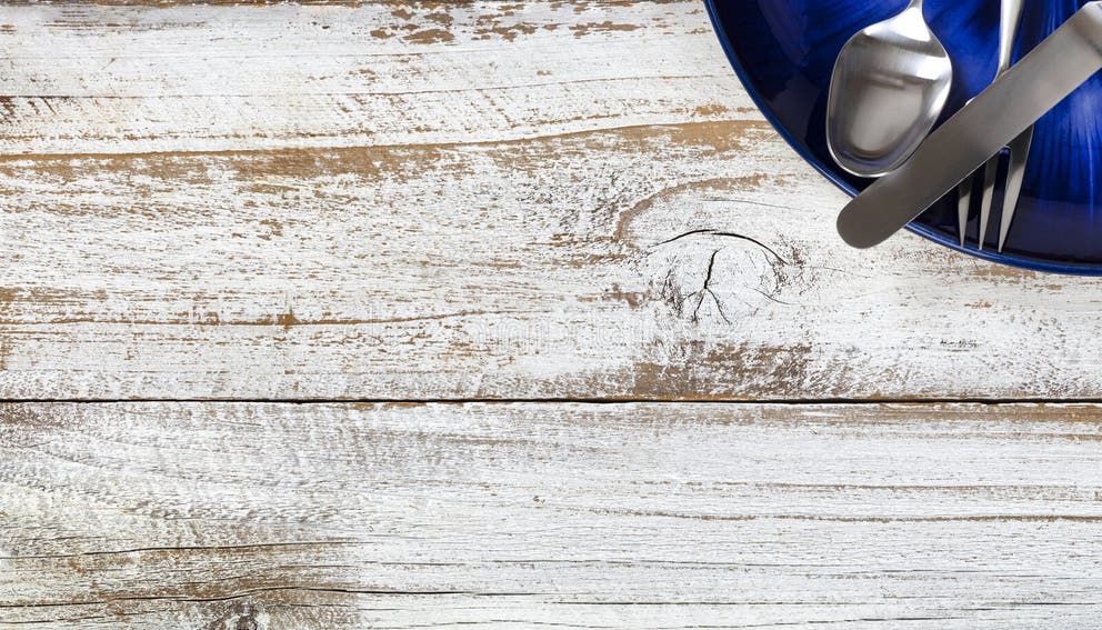 Partial Dinner Table Setting with Cutlery and Dark Blue Plate on White ...