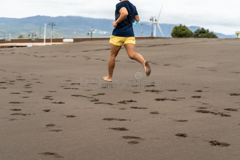 Partial Rear View of a Barefoot Man Running on the Beach Stock Image ...