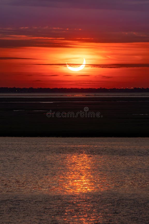 Partial Solar Eclipse with a Reflection in Water. Stock Image - Image ...