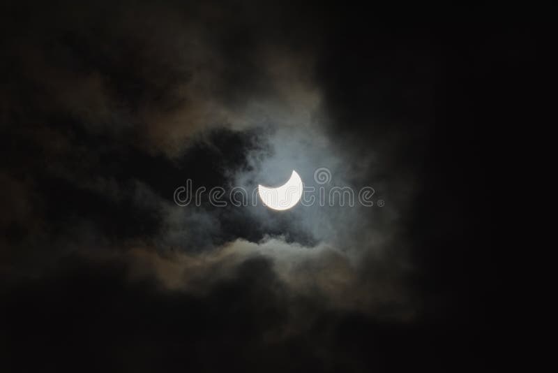 Partial Solar Eclipse Visible through the Clouds Stock Image - Image of ...