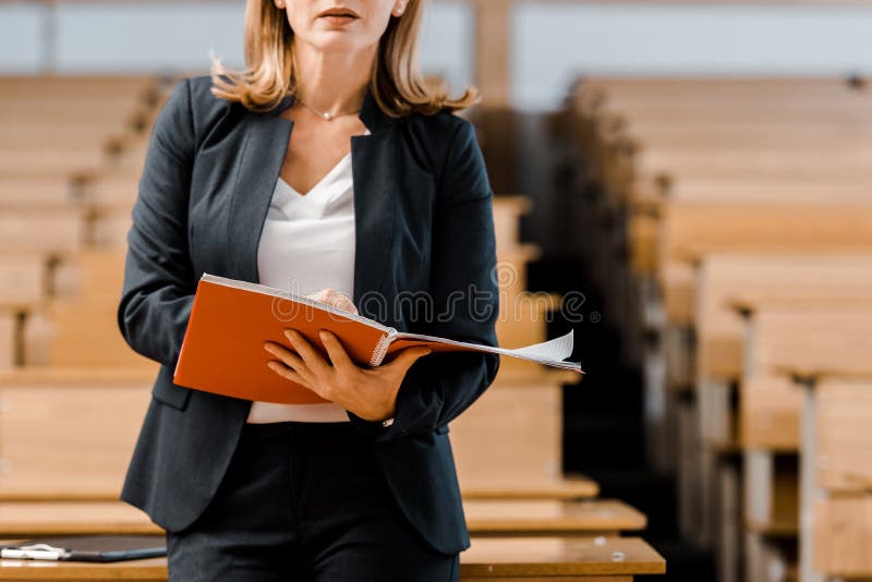 Partial View of Female University Professor Holding Journal and Writing ...