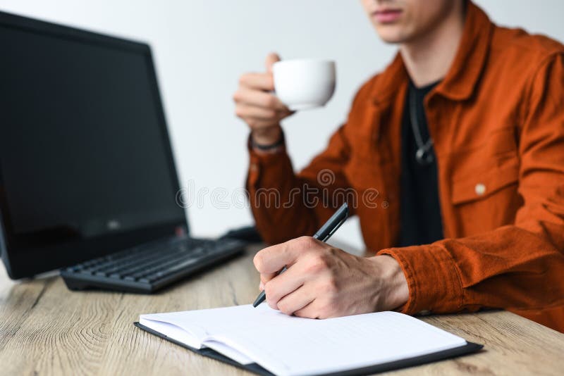 Partial View of Man Drinking Coffee and Writing in Textbook at Table ...