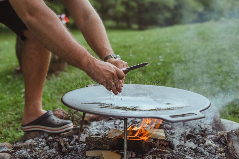 Partial View of a Man Frying Eggs on the Pan Over the Campfire Outdoors ...