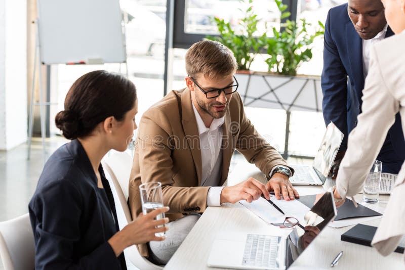 Partial View of Multiethnic Businesspeople at Table during Conference ... Partial View of Multiethnic Businesspeople at Table during Conference ...