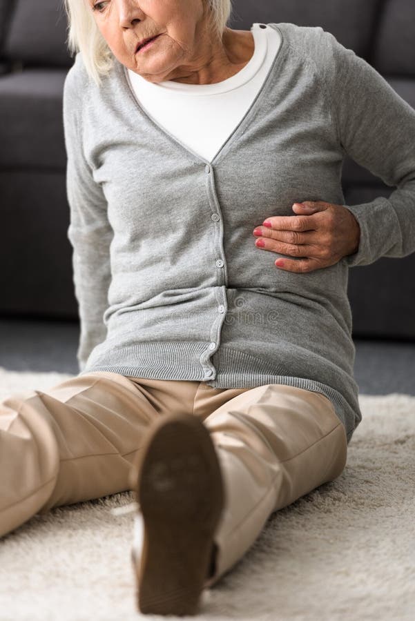 View of Senior Woman with Heart Attack Sitting on Carpet Stock Photo ...