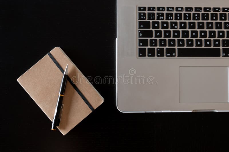 Partial View of a Silver Keyboard of a Laptop and a Notebook with a ...