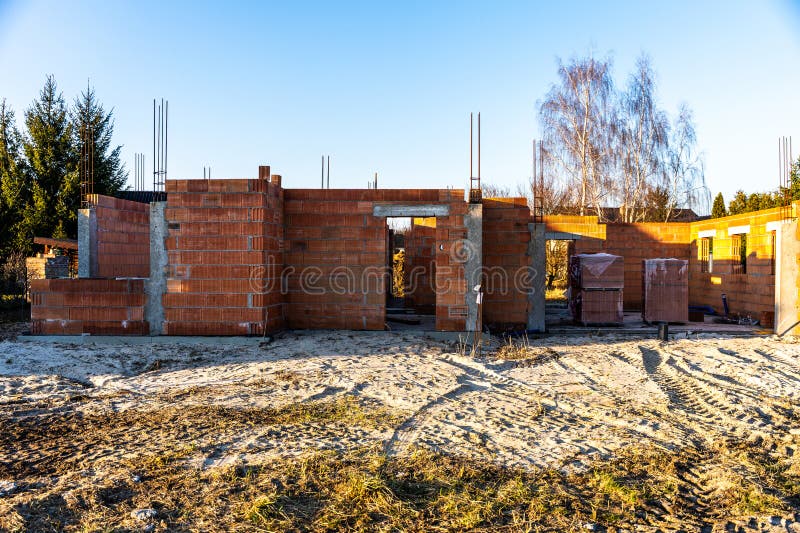 Unfinished Brick Building Under Construction on Sandy Ground with Rebar ...