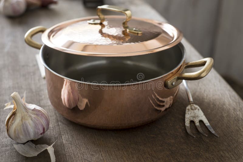 Partially Covered Copper Cooking Pot between Garlic and Carving Stock ...