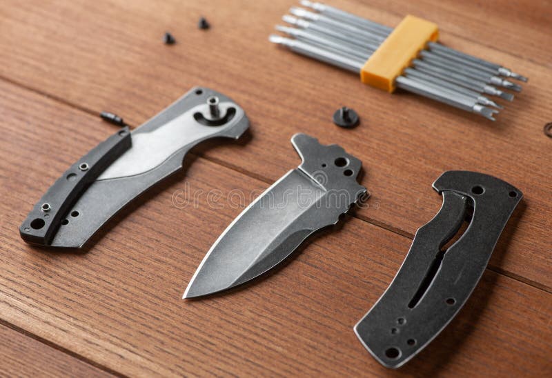 Parts of a Disassembled Knife and Set of Screwdriver Bits on a Wooden ...