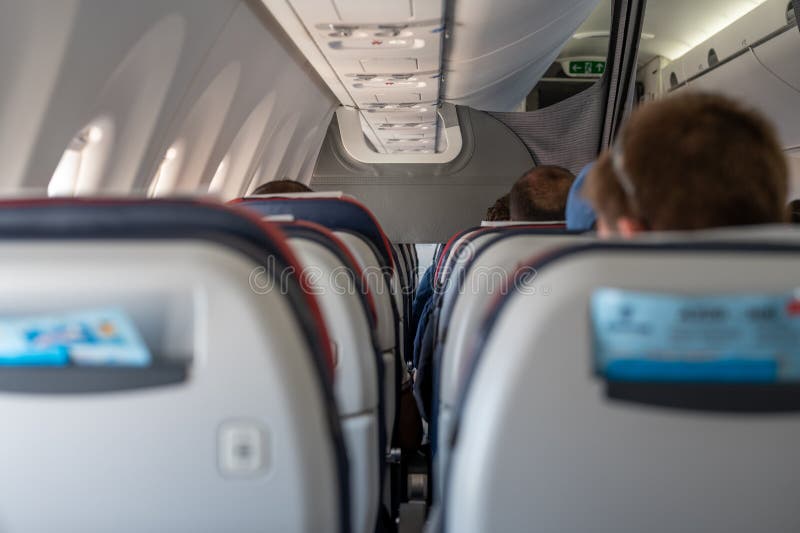 Passenger in a Airplane Cabin during a Flight Viewed from the Rear ...