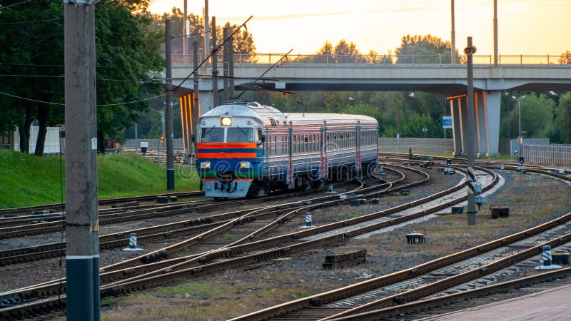 A Passenger Electric Train Passes by the Railway during Sunset. a Major ...