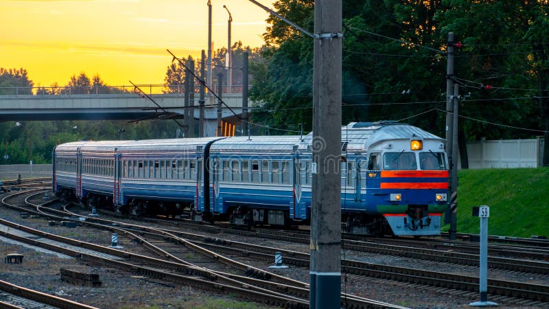 A Passenger Electric Train Passes by the Railway during Sunset. a Major ...