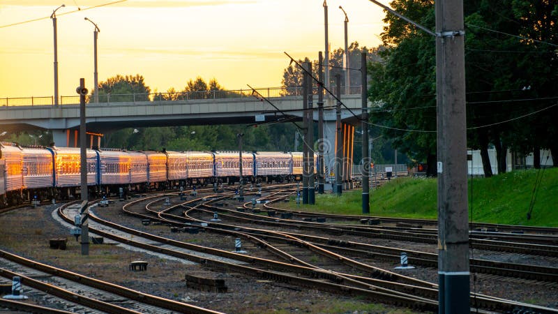 A Passenger Electric Train Passes by the Railway during Sunset. a Major ...