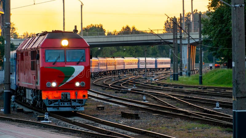 A Passenger Electric Train Passes by the Railway during Sunset. a Major ...