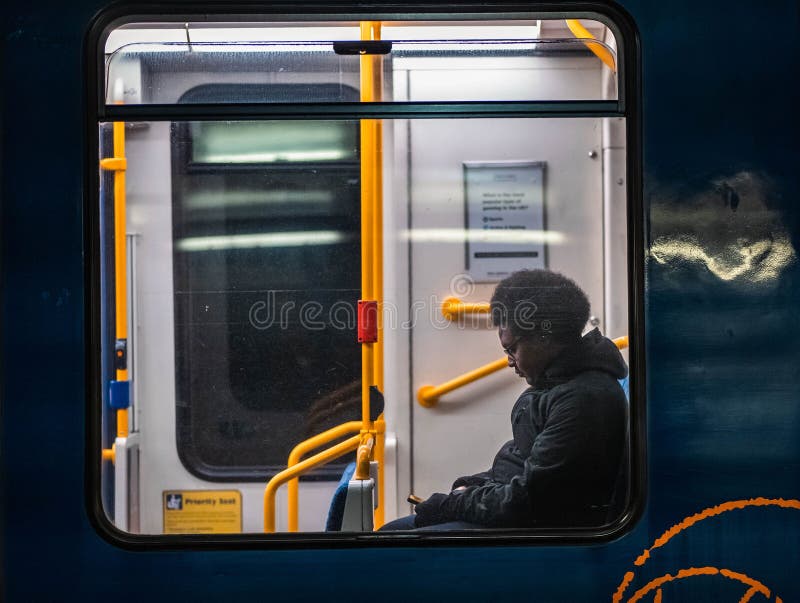 Passenger Holding a Smartphone Sitting on a Seat of a Public Bus ...