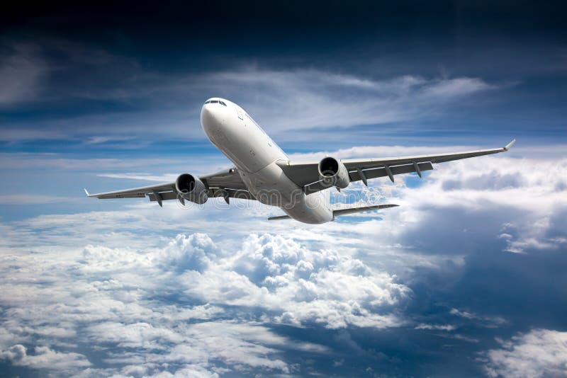Passenger Plane Flies High in the Blue Sky Above the Clouds. Front View ...