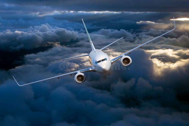 Passenger Plane Flies High in the Blue Sky Above the Clouds. Front View ...