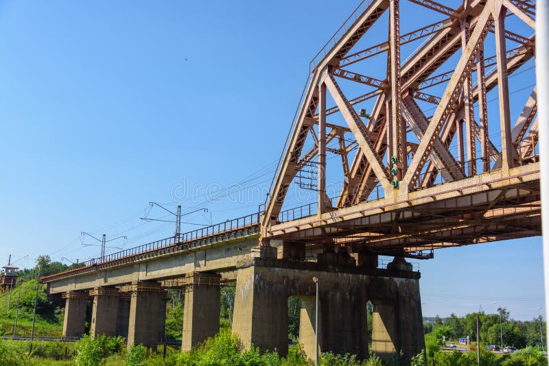 Passenger Train is Traveling Along the Railway Bridge Over the River ...