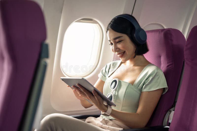Passenger Using Tablet Computer in Airplane Cabin during Flight ...