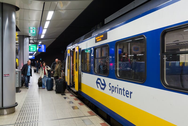 Passengers Board the Train at the Schiphol Railway Station. Editorial ...