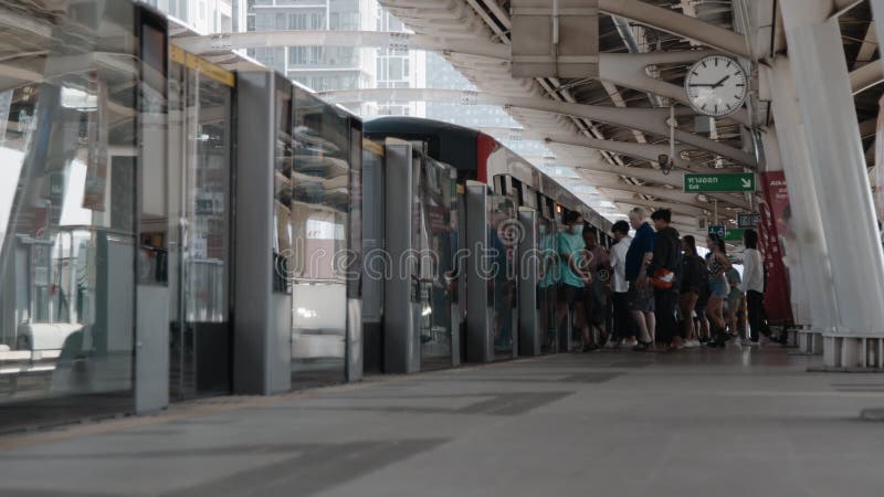 Passengers Waiting at a Modern Outdoor Train Station Platform with a ...