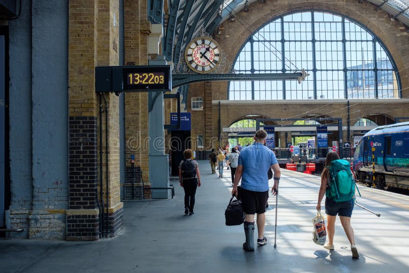 Passengers Walk through a Train Station Platform Featuring a Large ...