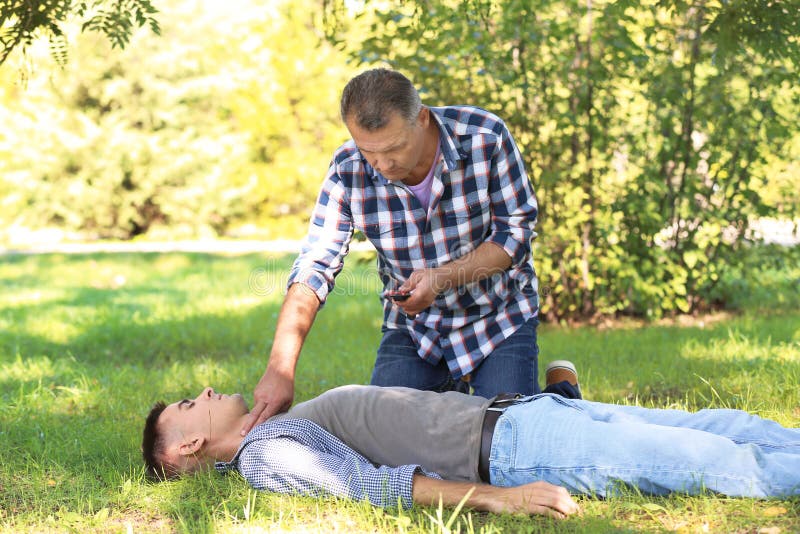 Passerby Calling Ambulance while Checking Pulse Stock Image - Image of ...