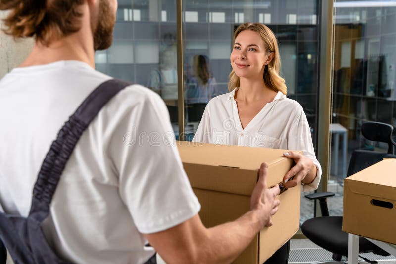 Worker of a Delivery Services Office Passing the Package To the ...