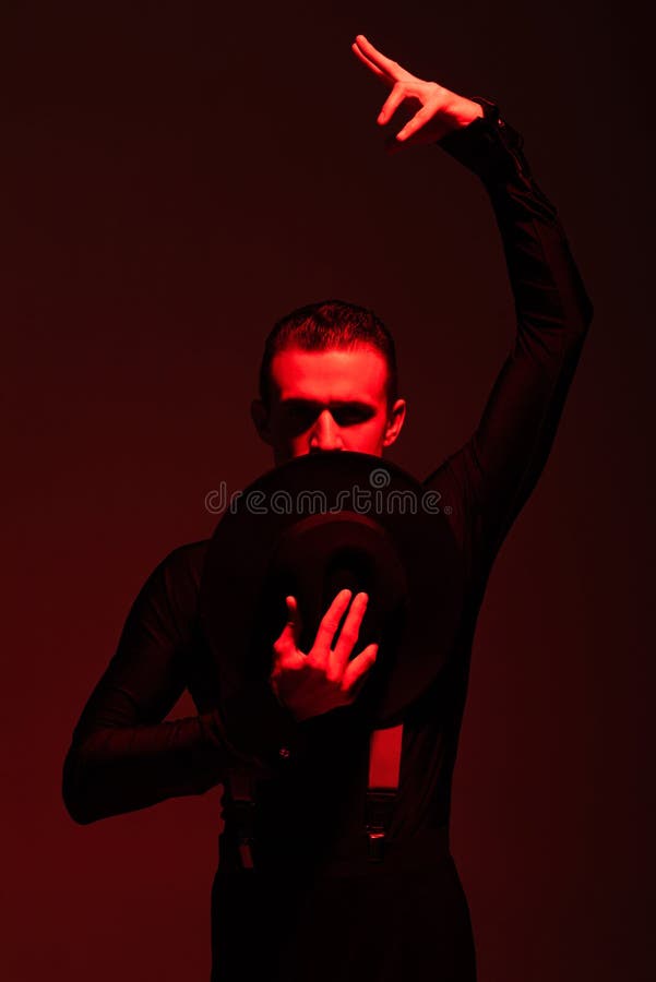 Dancer Looking at Camera and Holding Hat Near Face while Performing ...