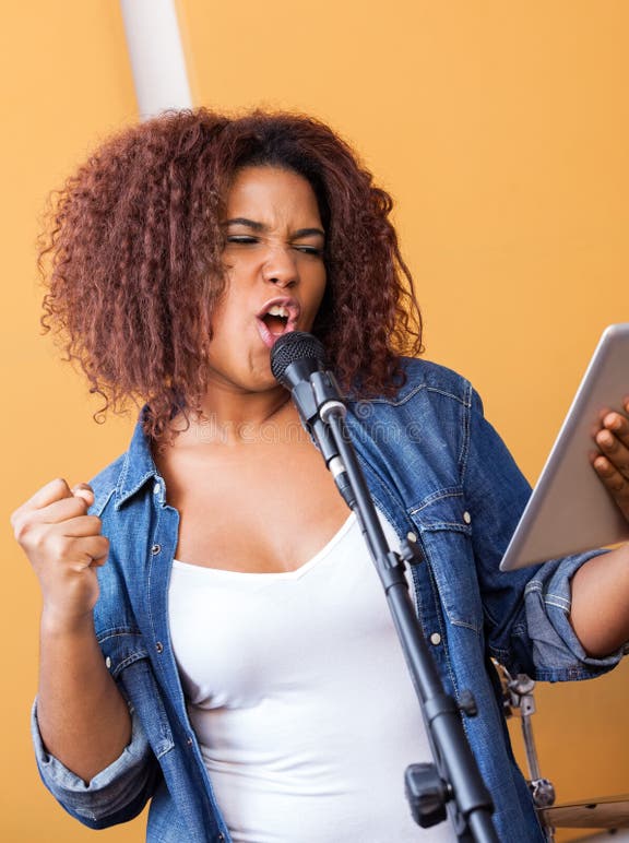 Passionate Singer Holding Tablet Computer while Performing Stock Photo ...
