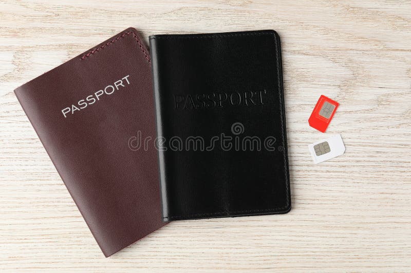 Passports and SIM Cards on Wooden Table, Flat Lay Stock Image - Image ...