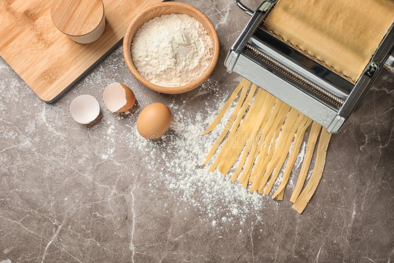 Pasta Maker with Dough and Products on Kitchen Table Stock Photo ...