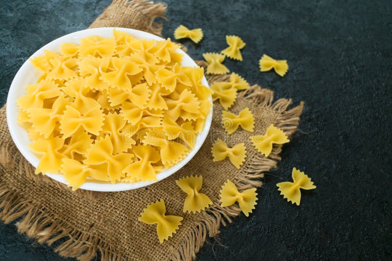 Pasta in the Shape of a Bow in a Plate on a Black Background.Copy Space ...