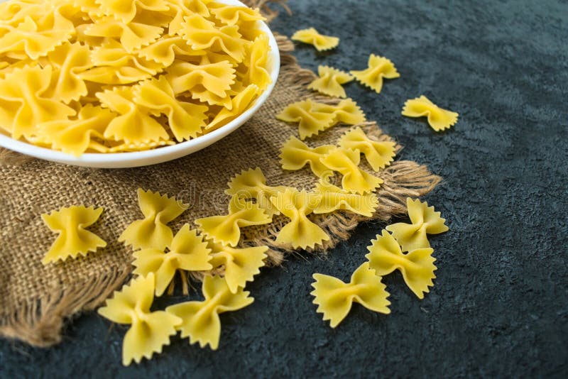 Pasta in the Shape of a Bow in a Plate on a Black Background.Close-up ...