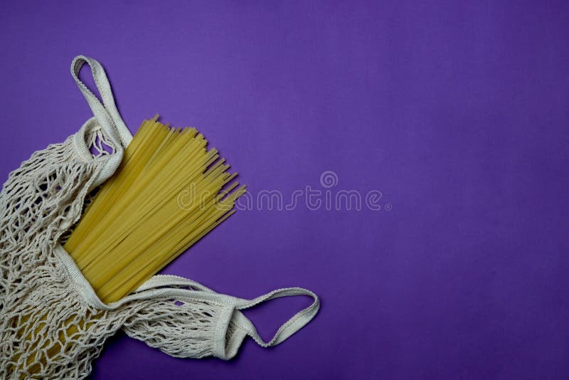 Pasta, Spaghetti in a String Bag on a Purple Table. View from Above ...