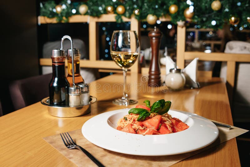 Pasta Tagliatelle with Tomatoes on a White Plate on a Table in a ...