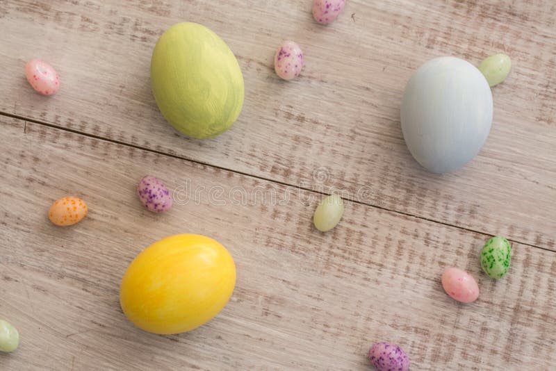 Pastel Colored Easter Eggs and Jelly Beans on White Wood Background ...
