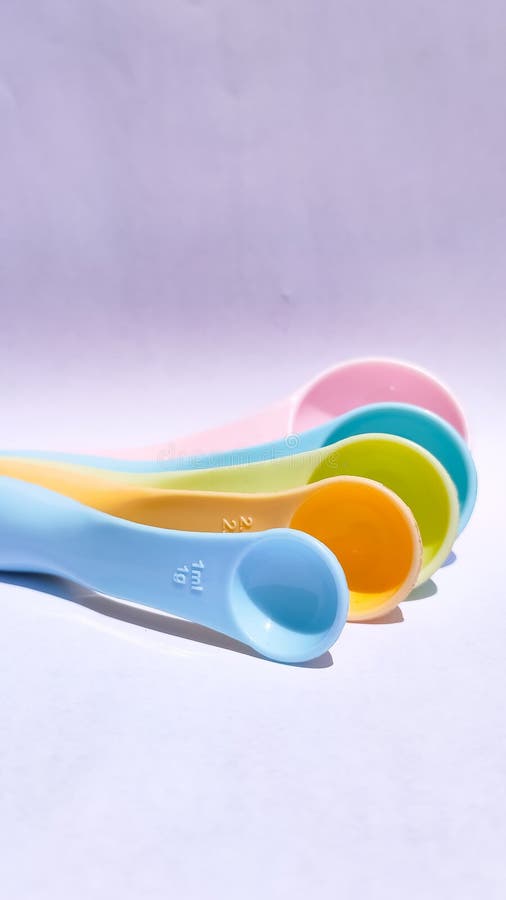 Pastel Colored Plastic Measuring Spoons on a White Background Stock ...