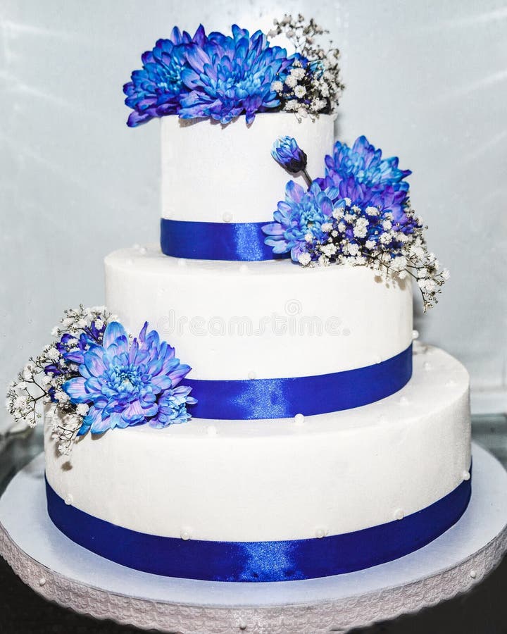 Pastel De Bodas Con Las Cintas Azules Y Las Flores Foto de archivo ...