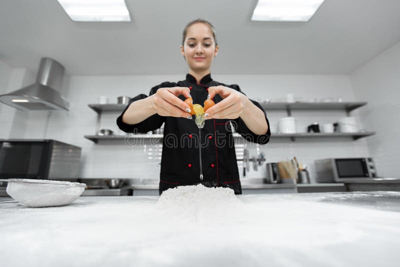 Pastry Chef Cracking an Egg Over White Flour. Stock Photo - Image of ...