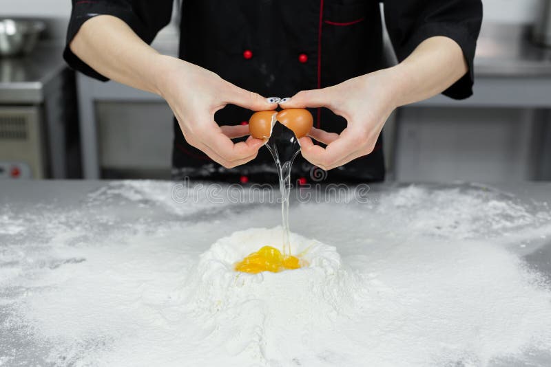 Pastry Chef Cracking an Egg Over White Flour. Stock Image - Image of ...