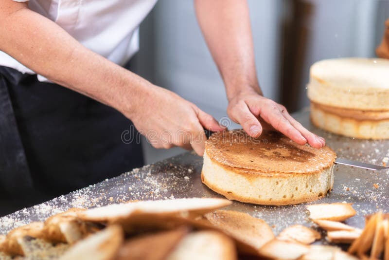 Pastry Chef Cutting the Sponge Cake on Layers. Cake Production Process ...