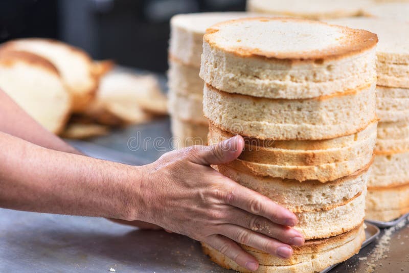 Pastry Chef Cutting the Sponge Cake on Layers. Cake Production Process ...