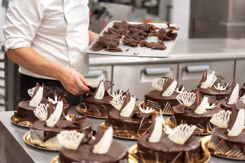 Pastry Chef Decorating Chocolate Cakes in the Kitchen of Pastry Shop ...