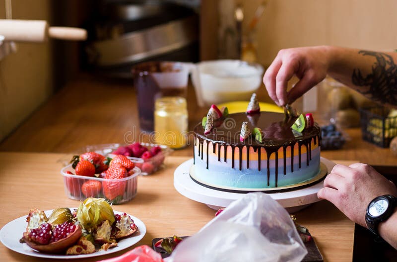 Pastry Chef in the Kitchen Decorating a Cake of Chocolate,fruit,candies ...