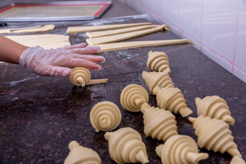 A Pastry Chef in the Kitchen is Making Pastries. Chef Rolls the Cut ...
