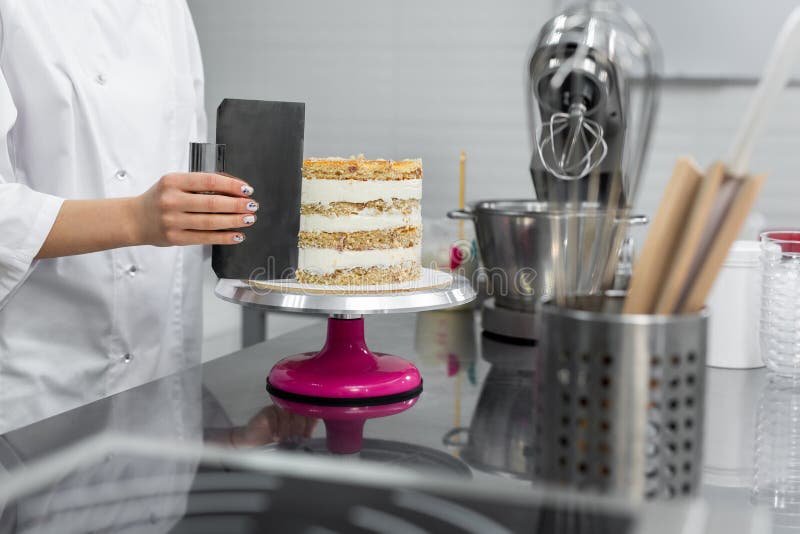 The Pastry Chef Levels the Cake with Cream. Stock Image - Image of ...