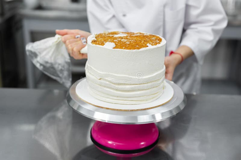 The Pastry Chef Levels the Cake with Cream. Stock Photo - Image of ...
