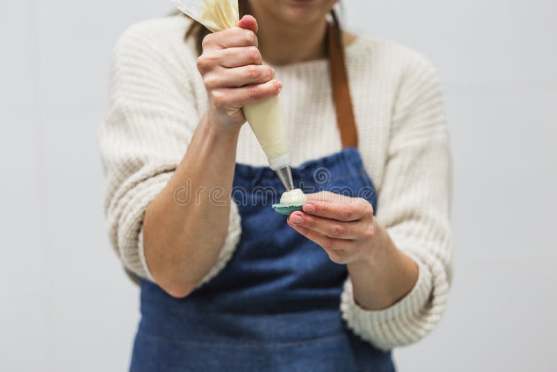 Pastry Chef Using a Pastry Bag with Cream To Fill the Macaroons while ...