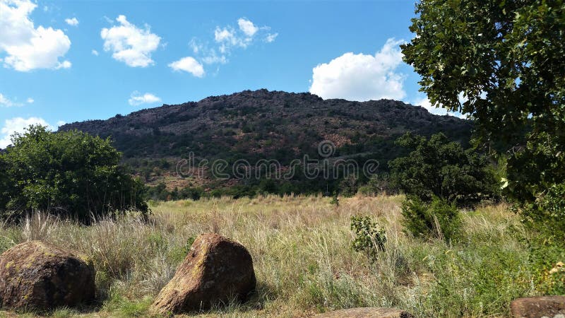 Pasture with Rocks and a Mountain Stock Photo - Image of background ...